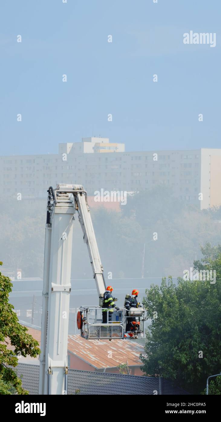 View of firefighters using platform truck to extinguish fire from ...