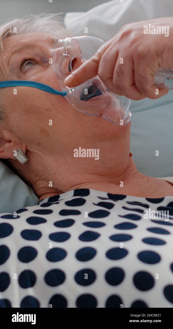 Doctor putting oxygen mask on face of hyperventilating patient with ...