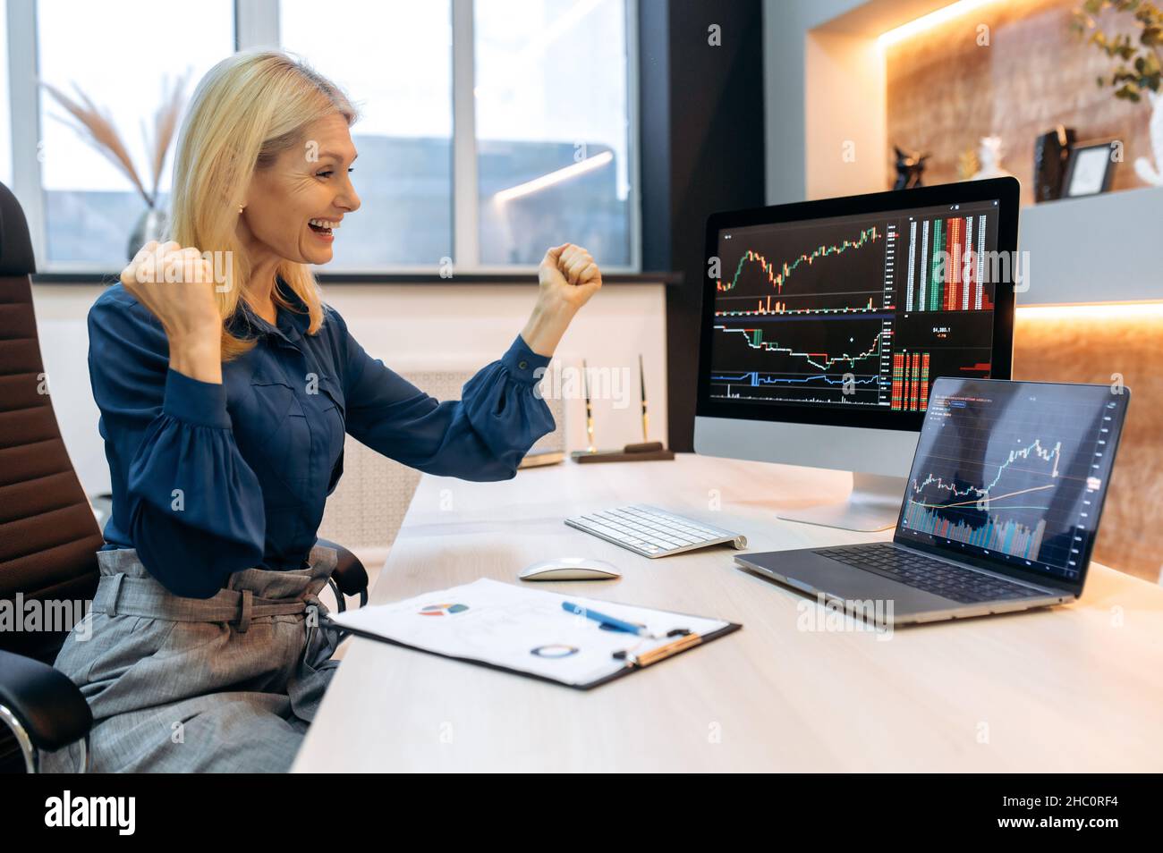 Happy joyful mature blonde business woman, trade broker, stock trader ...