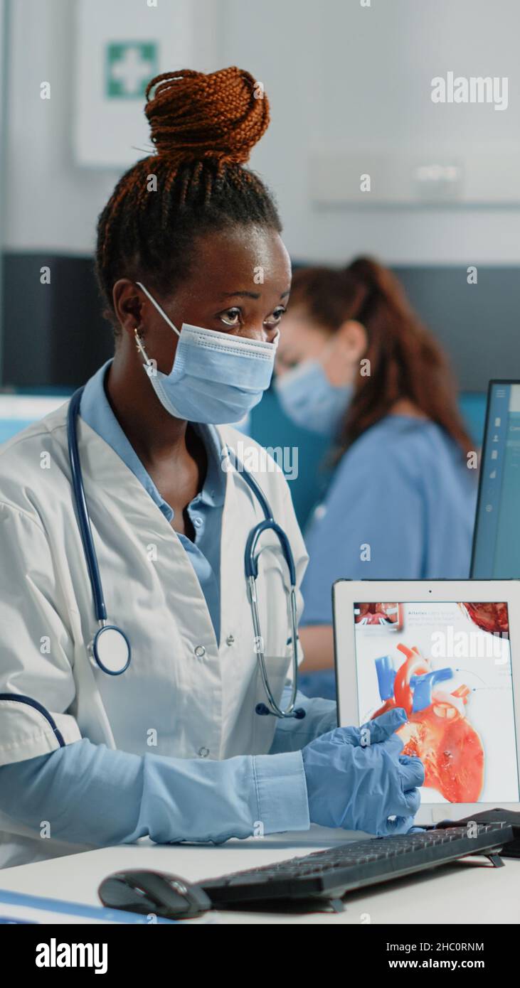 Doctor pointing at tablet with heart organ on screen, explaining ...