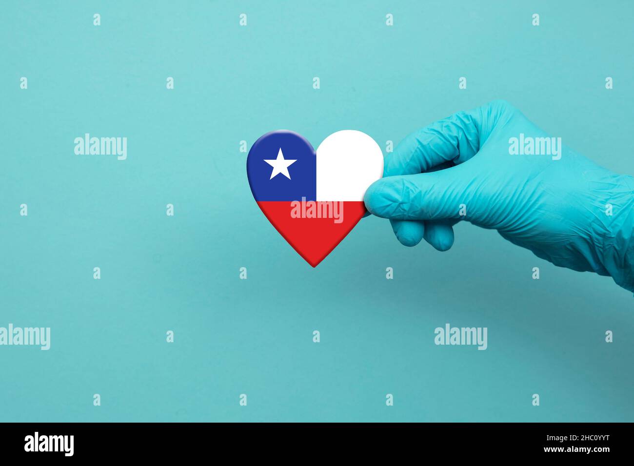 Medical workers hand wearing surgical glove holding Chile flag heart ...