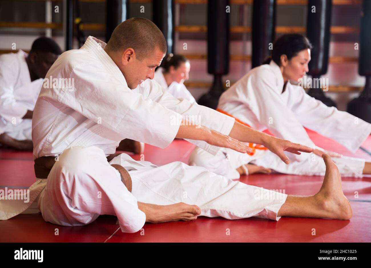 Man and woman in kimono warming up before karate training. They're ...