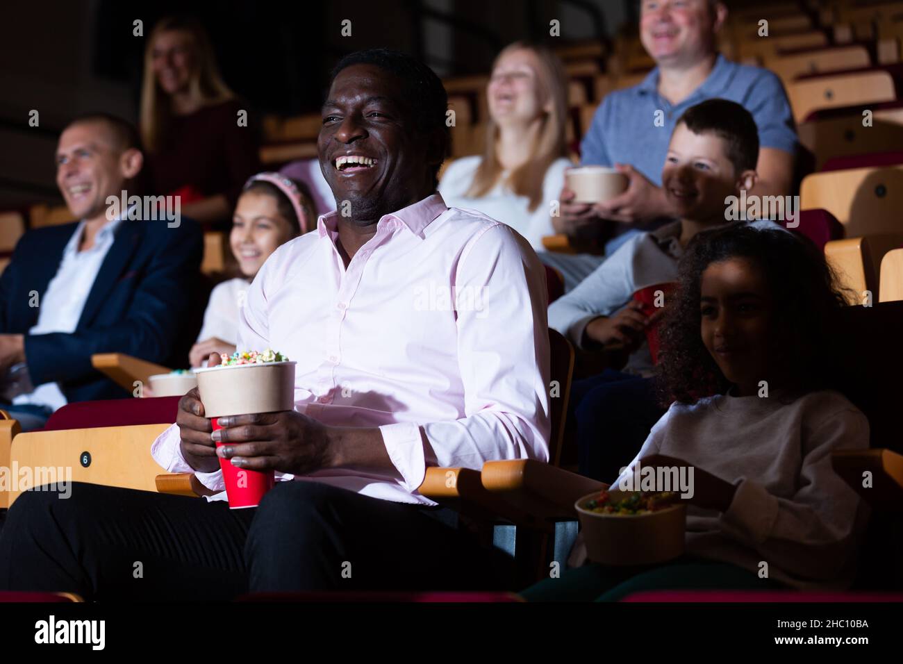 Laughing african american man watching comedy in movie theater Stock ...