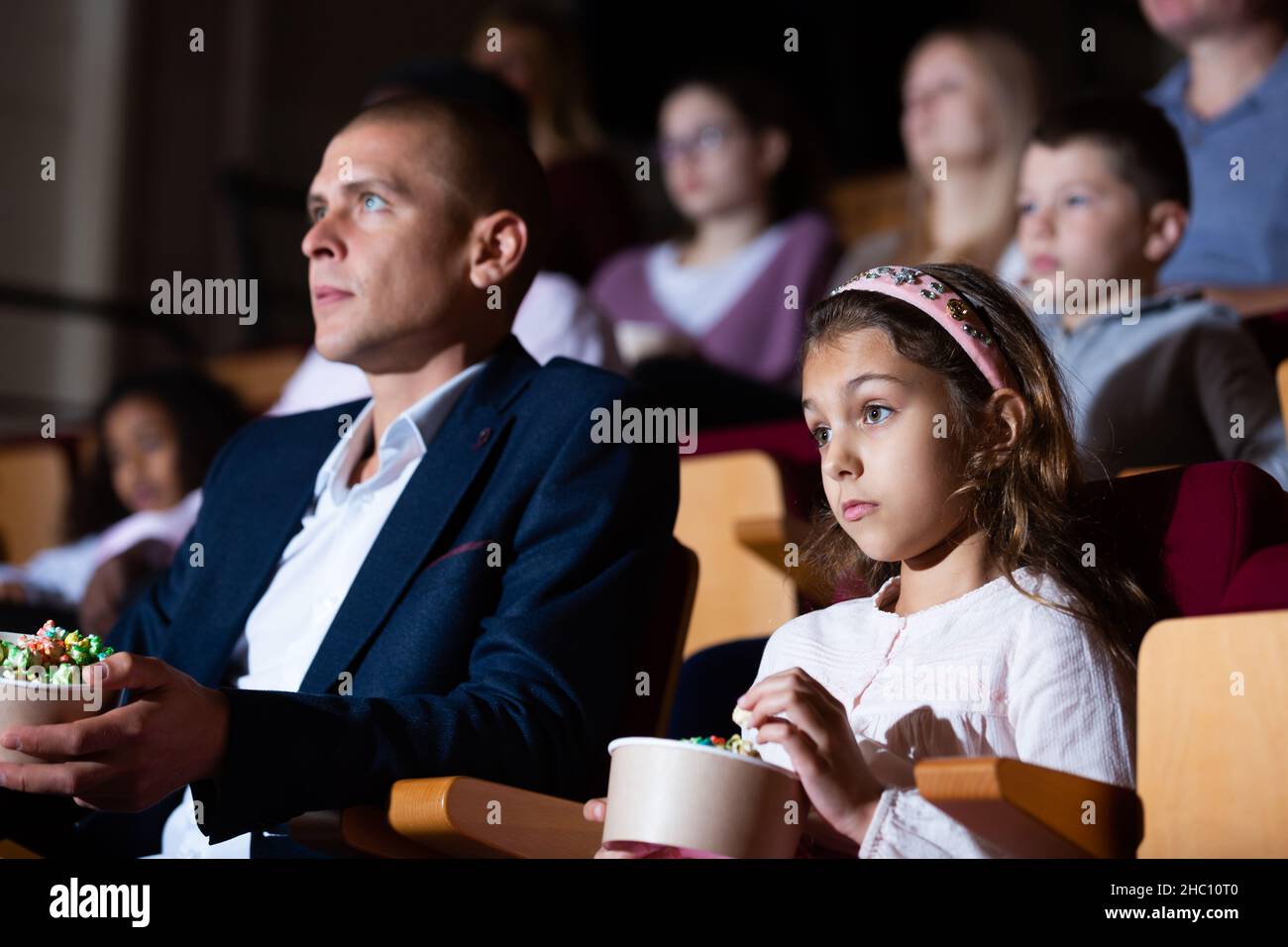 Dad and daughter carefully watch a movie in cinema hall Stock Photo - Alamy