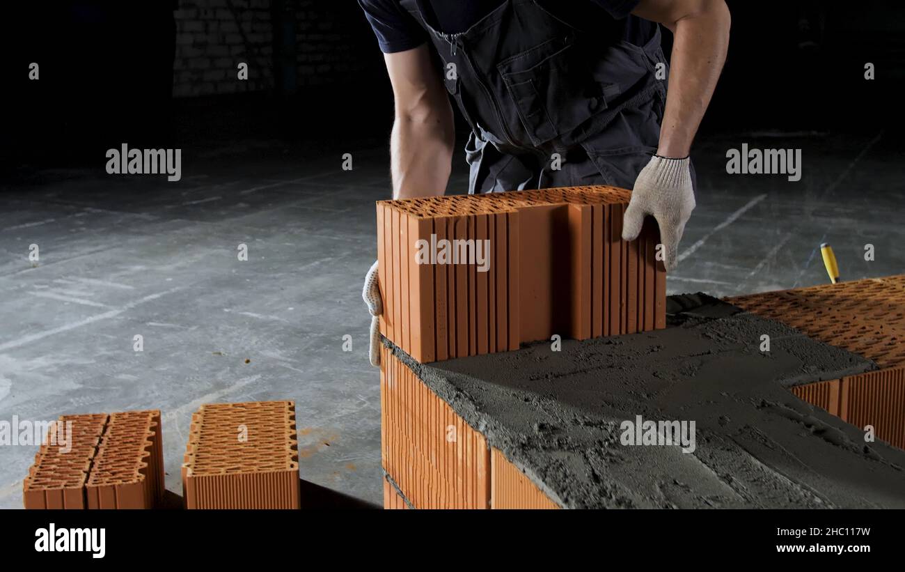 Bricklayer working at the construction site, making another layer of a ...