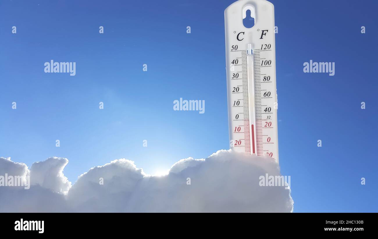 The thermometer in winter lies on the snow and shows low negative air ...
