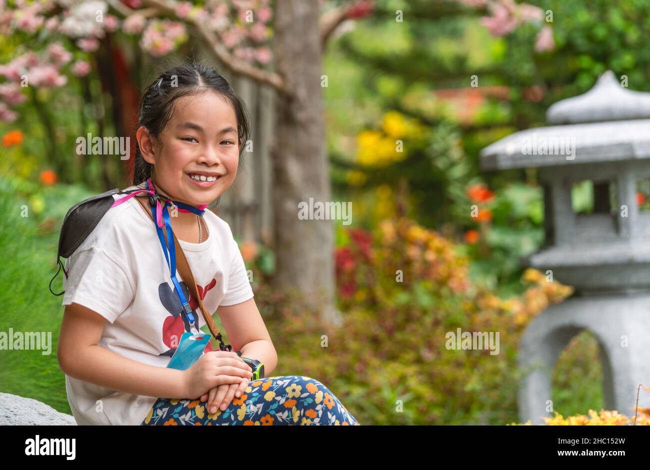 Portrait of cute Asian smiling child girl sits in Japanese garden, big ...