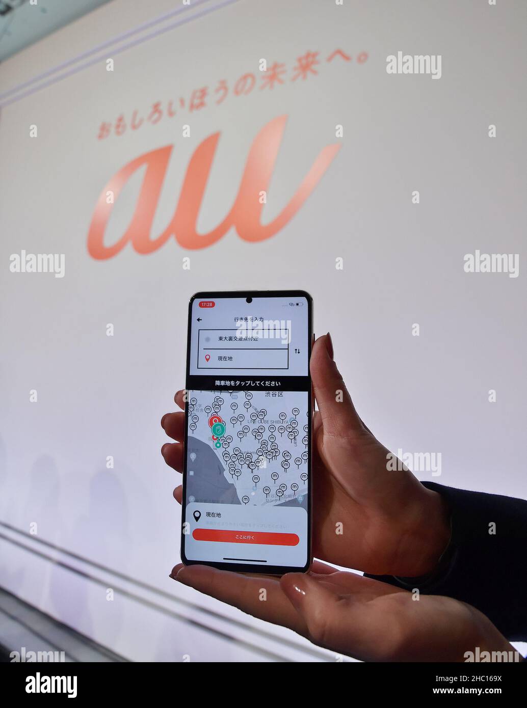 A staff shows a application of "Mobi" during a press conference for new ...