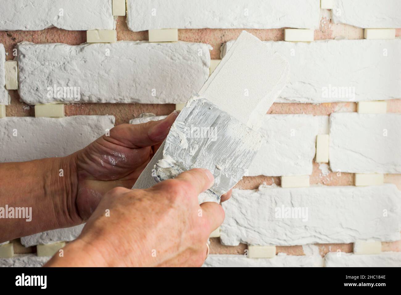 the master applies the adhesive solution with a spatula to the ...