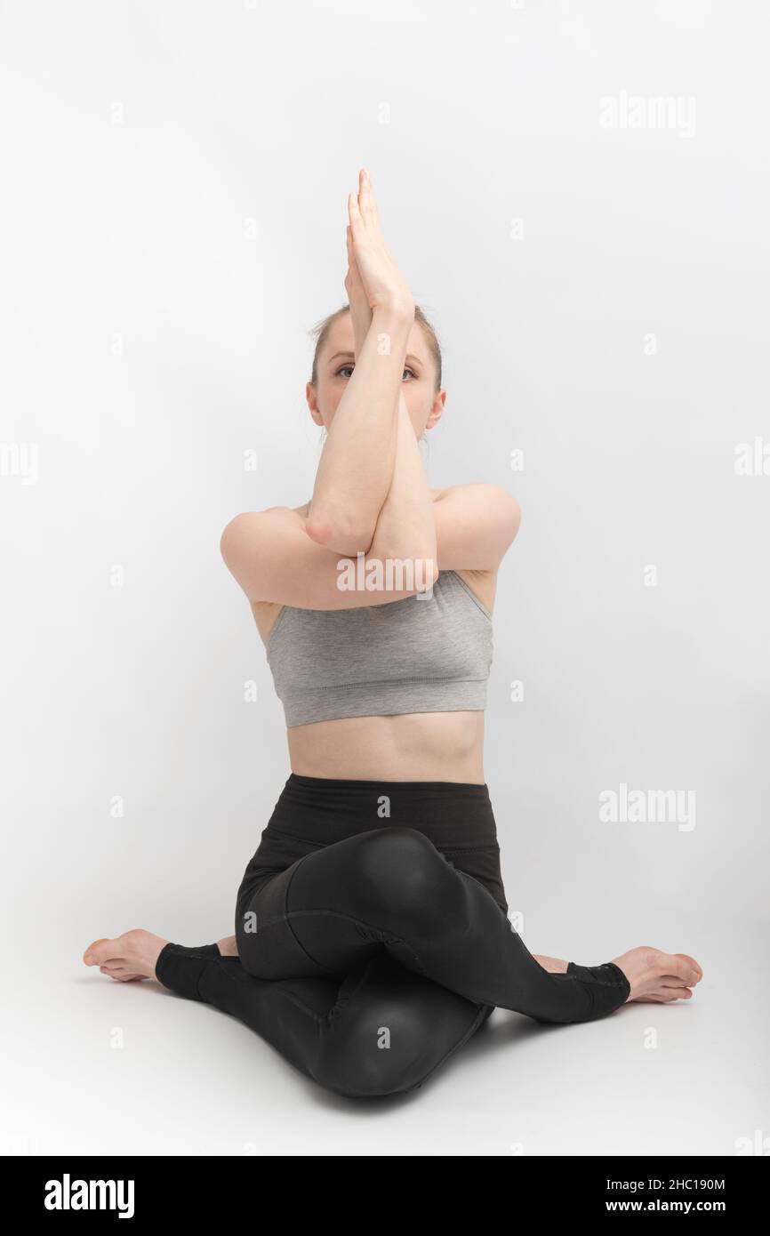 Gomukhasana. Cow Face Pose. Beautiful young woman practices yoga asanas ...