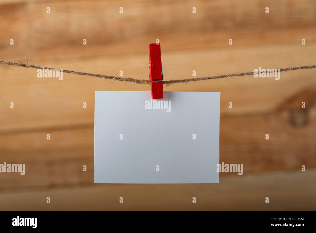 Blank white note card hanging with clothespin on rope string peg ...