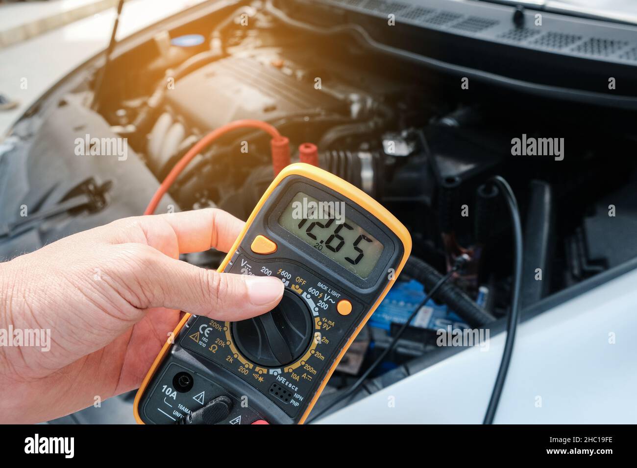 Mechanic hand use multimeter voltmeter to check the voltage level in a ...