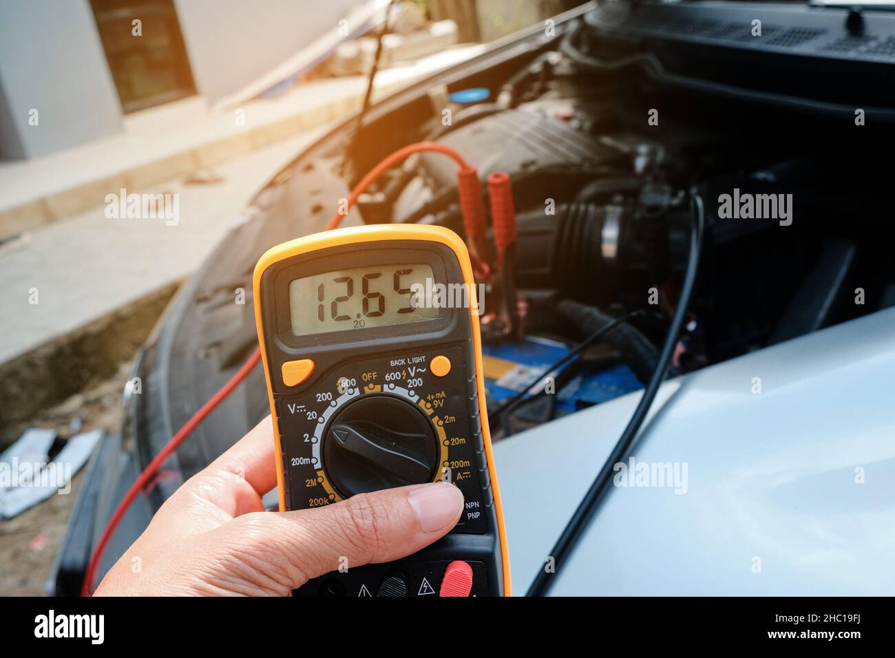 Mechanic hand use multimeter voltmeter to check the voltage level in a ...