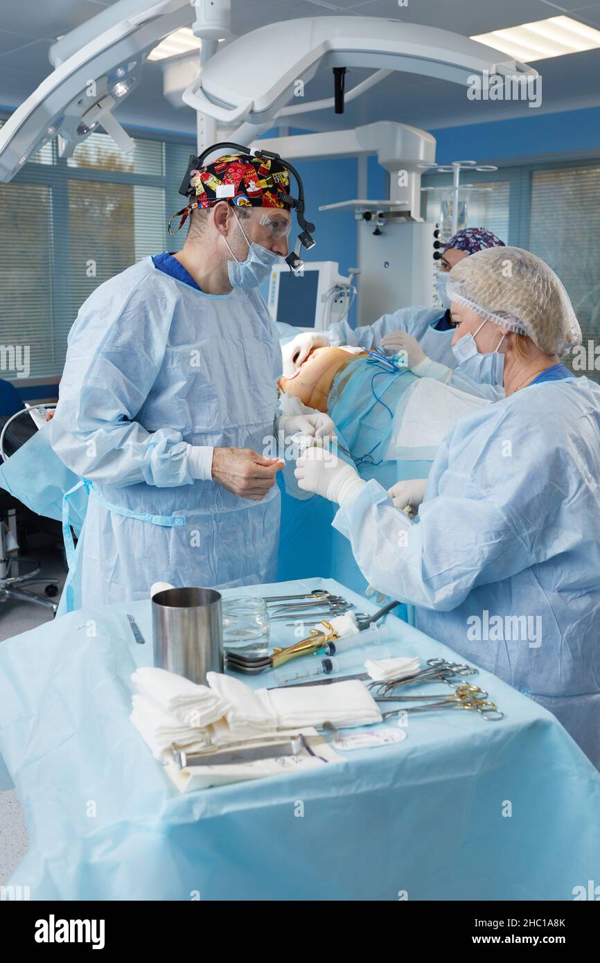 Surgeon and the nurse are preparing for surgery in the operating room ...