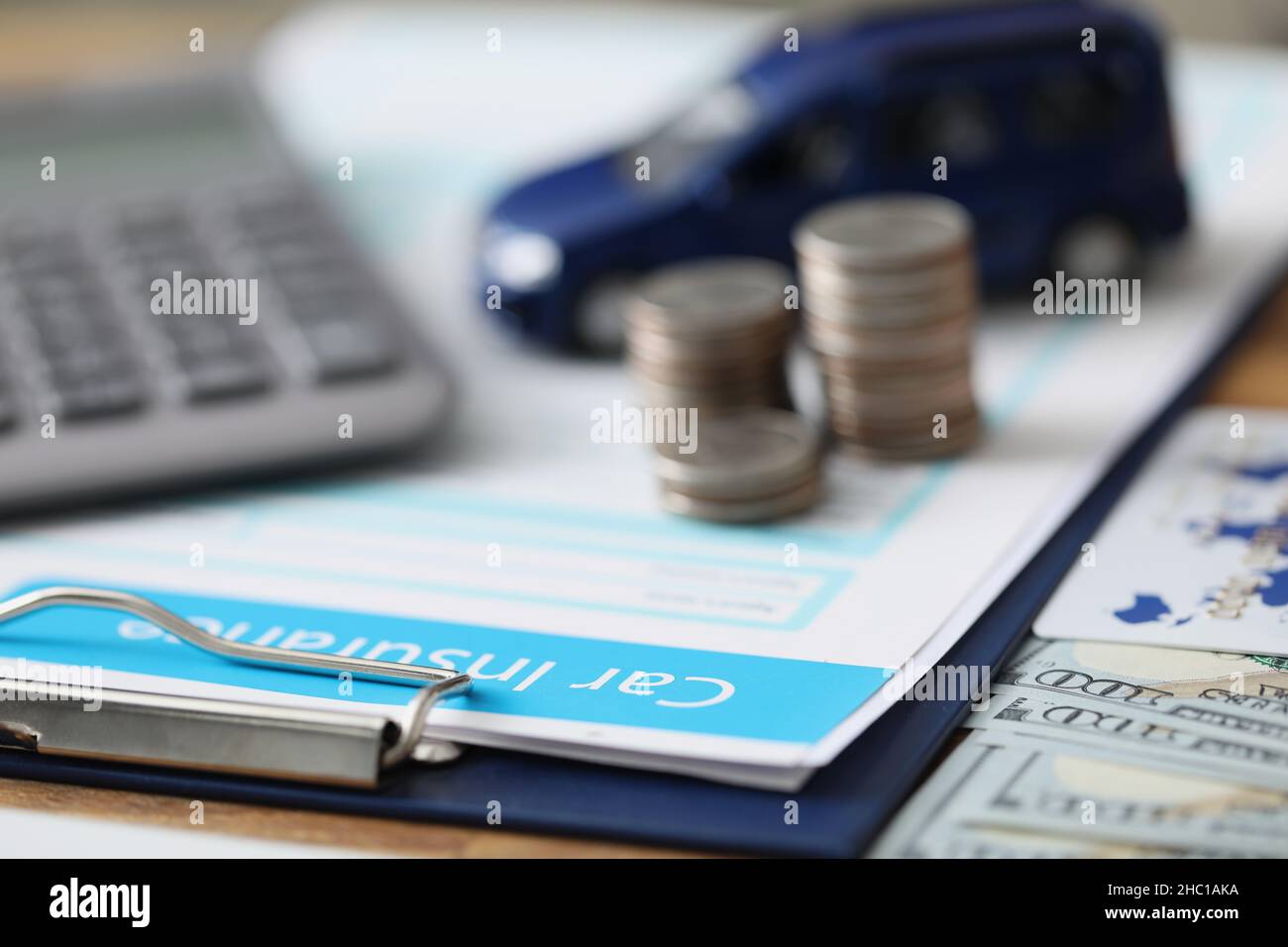Car insurance paper, calculator and stack of coins on workplace Stock ...