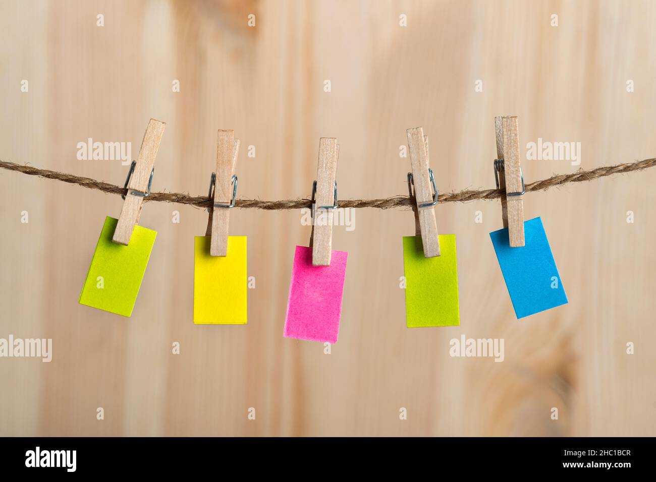Small multicolored notes hang with clothespins on rope. Copy space ...