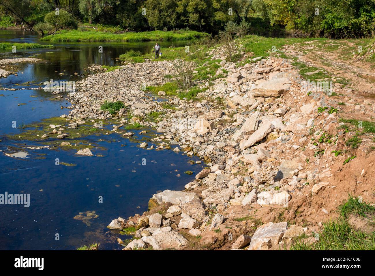 River bank fortified from erosion by stones and concrete debris Stock ...