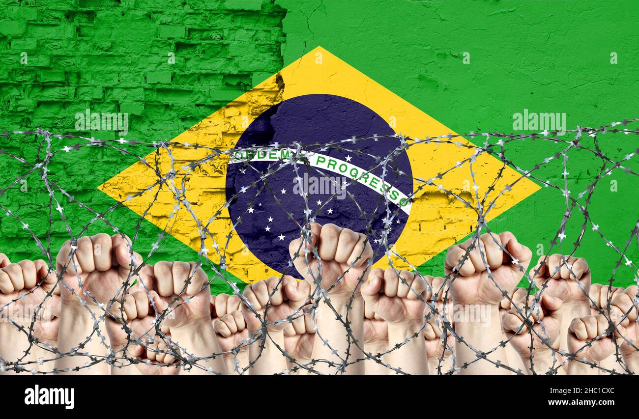 Barbed wire against the background of the inflicted flag of Brazil and ...