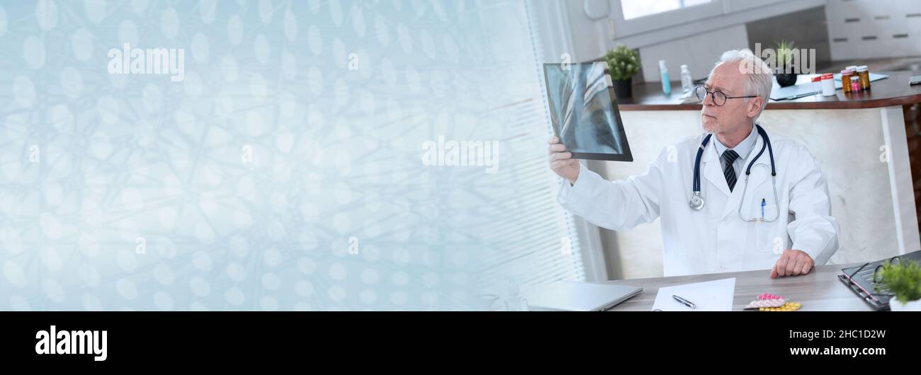 Senior doctor looking at x-ray in medical office; panoramic banner ...