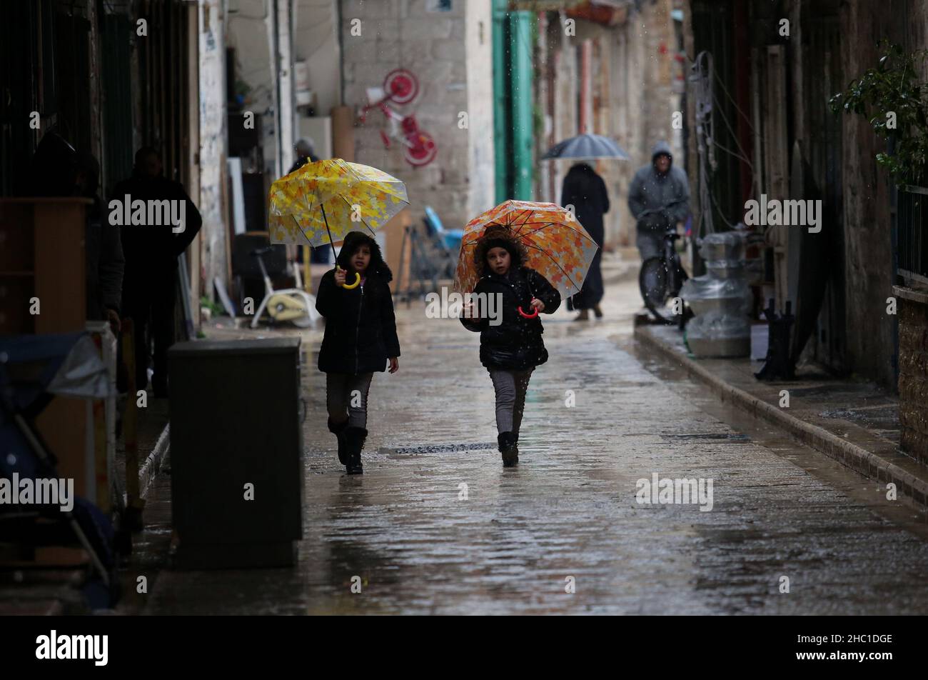 Nablus. 21st Dec, 2021. Palestinians walk on a street in the rain in ...