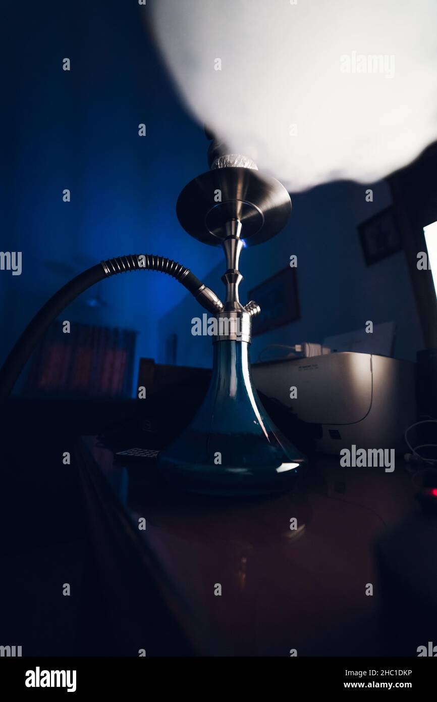 A metal big hookah in a dark blue illuminated room Stock Photo - Alamy