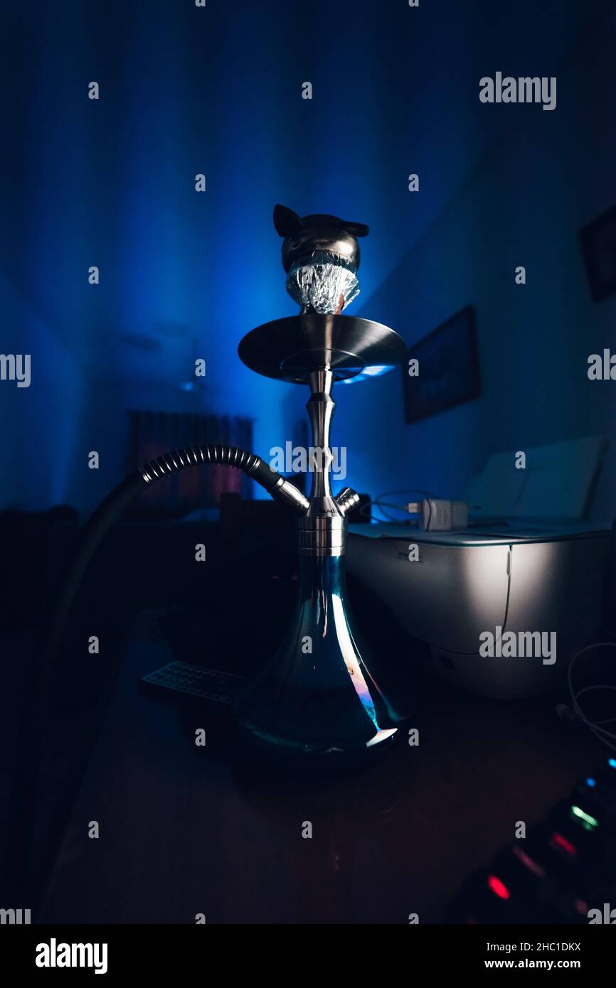 A metal big hookah in a dark blue illuminated room Stock Photo - Alamy