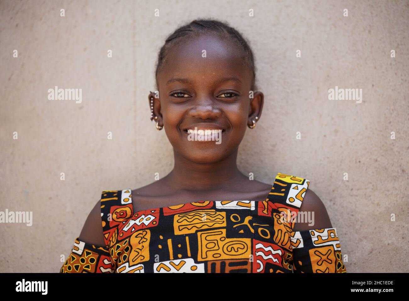 Portrait of a pretty little black african girl smiling at the camera ...