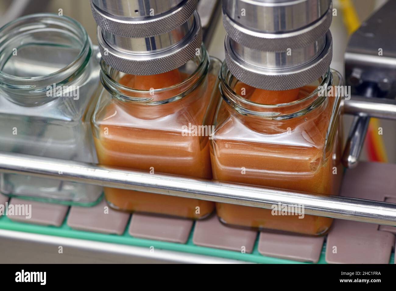 Jars of creamed honey in a packaging line at a commercial honey factory ...