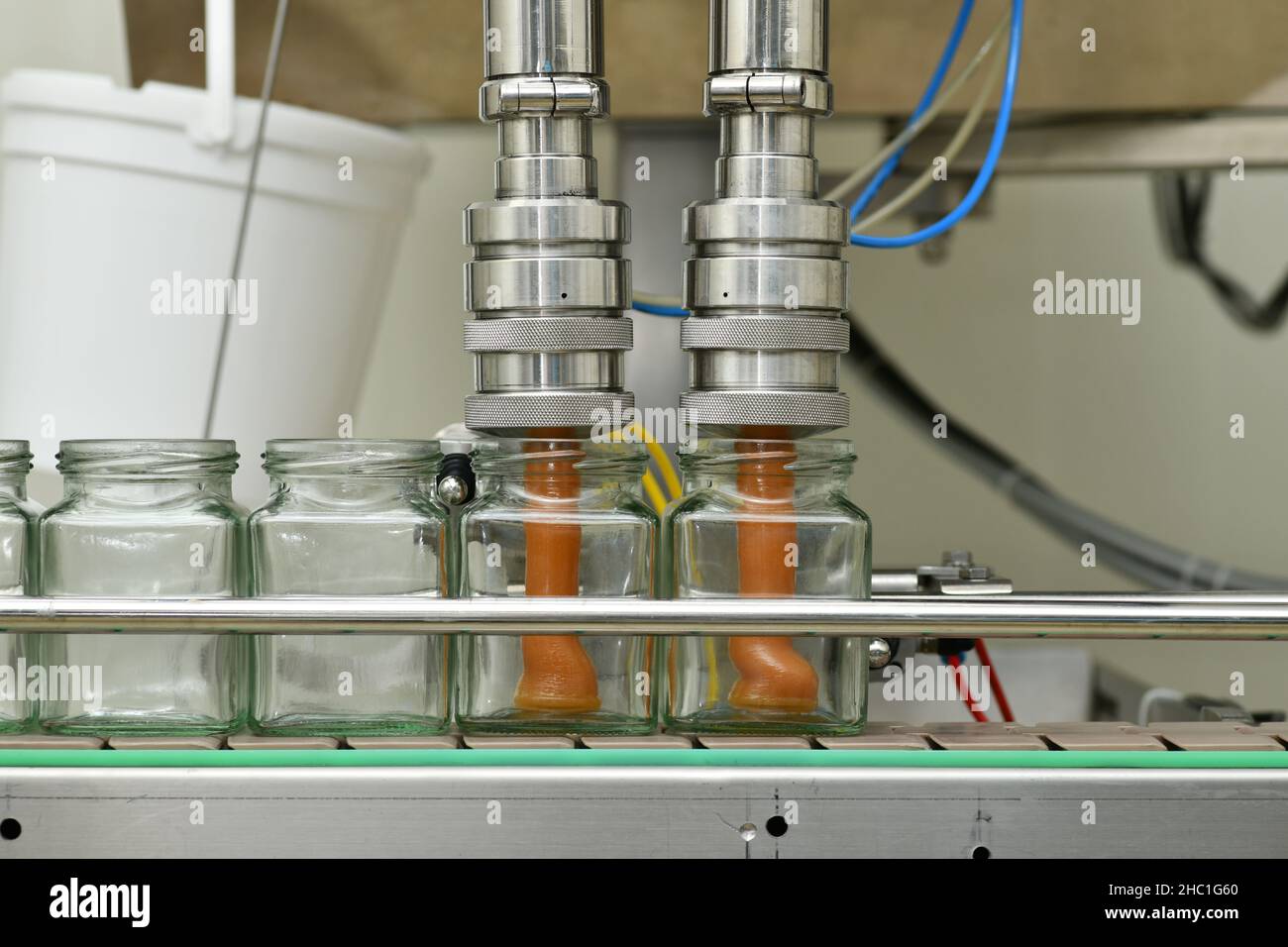 Jars of creamed honey in a packaging line at a commercial honey factory ...