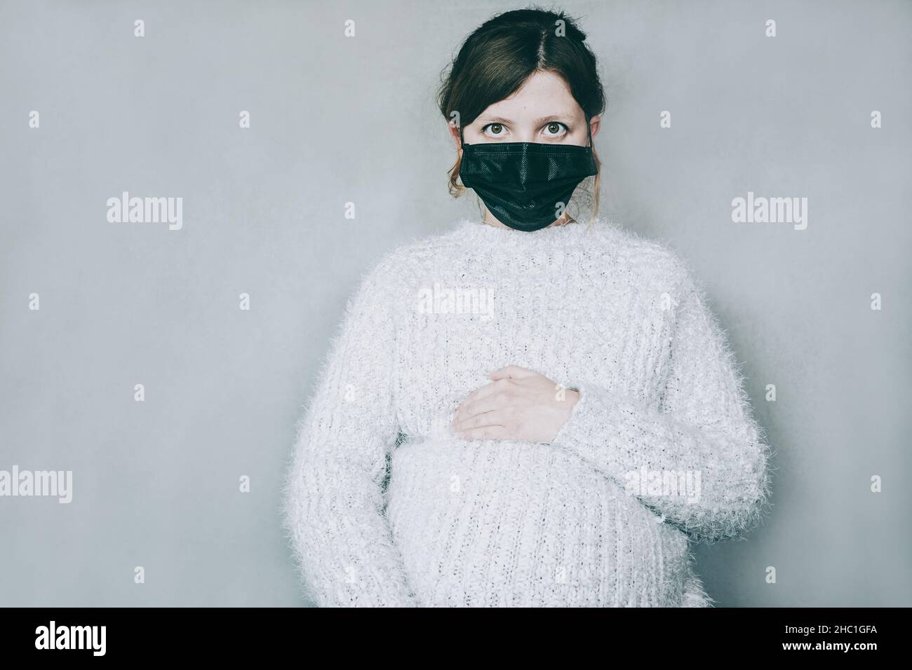Young pregnant woman wearing a mask during covid 19 pandemic Stock ...
