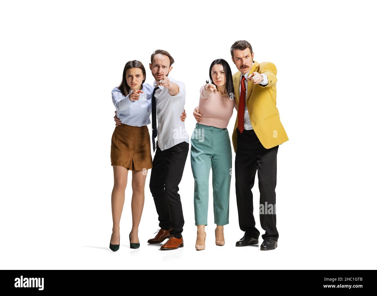 Full-length portrait of four people, office workers pointing at camera ...