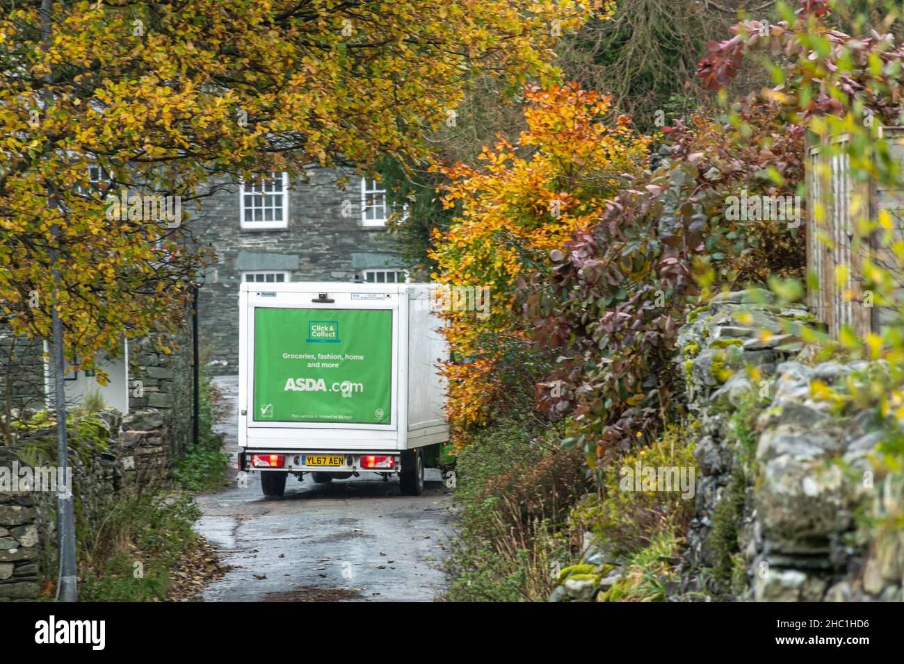 Asda delivery van driving through a narrow country lane in the village ...