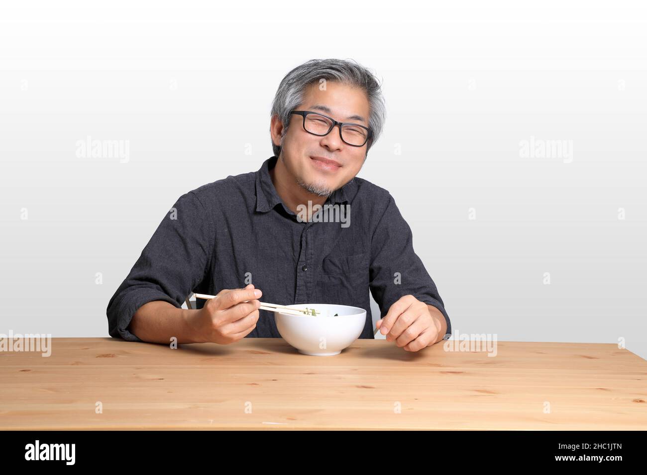 The senior Asian man eating noodle on the white background Stock Photo ...