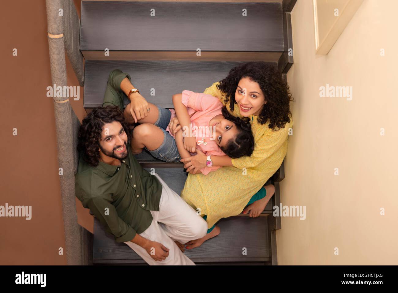 Overhead view of family members sitting on stairs at home Stock Photo ...