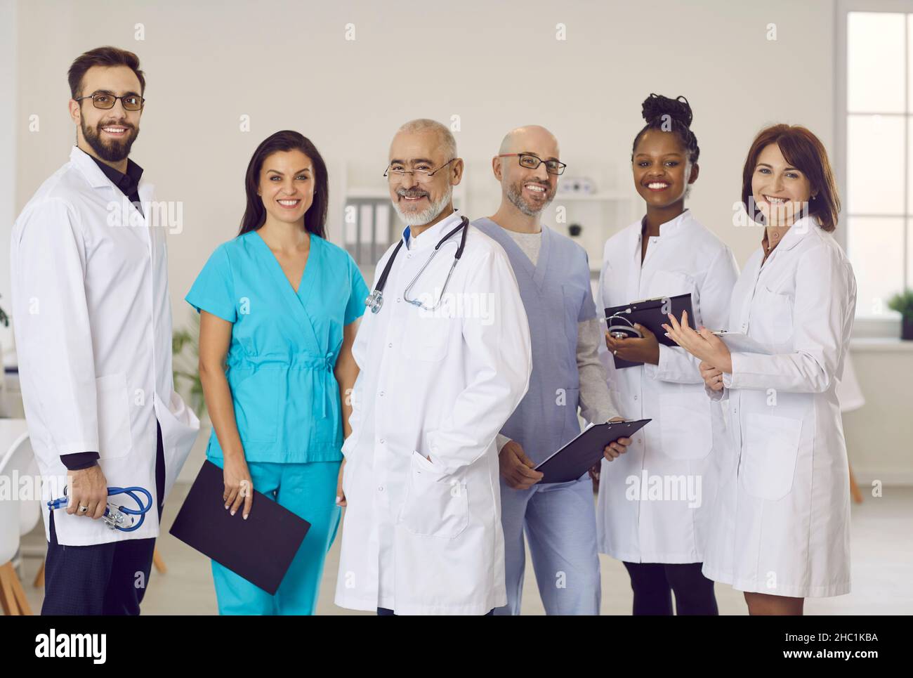 Diverse group of happy young and senior doctors and other clinic ...