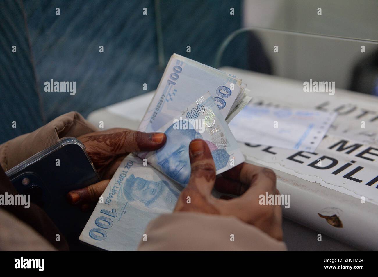 (211216) -- ANKARA, Dec. 16, 2021 (Xinhua) -- A customer counts ...