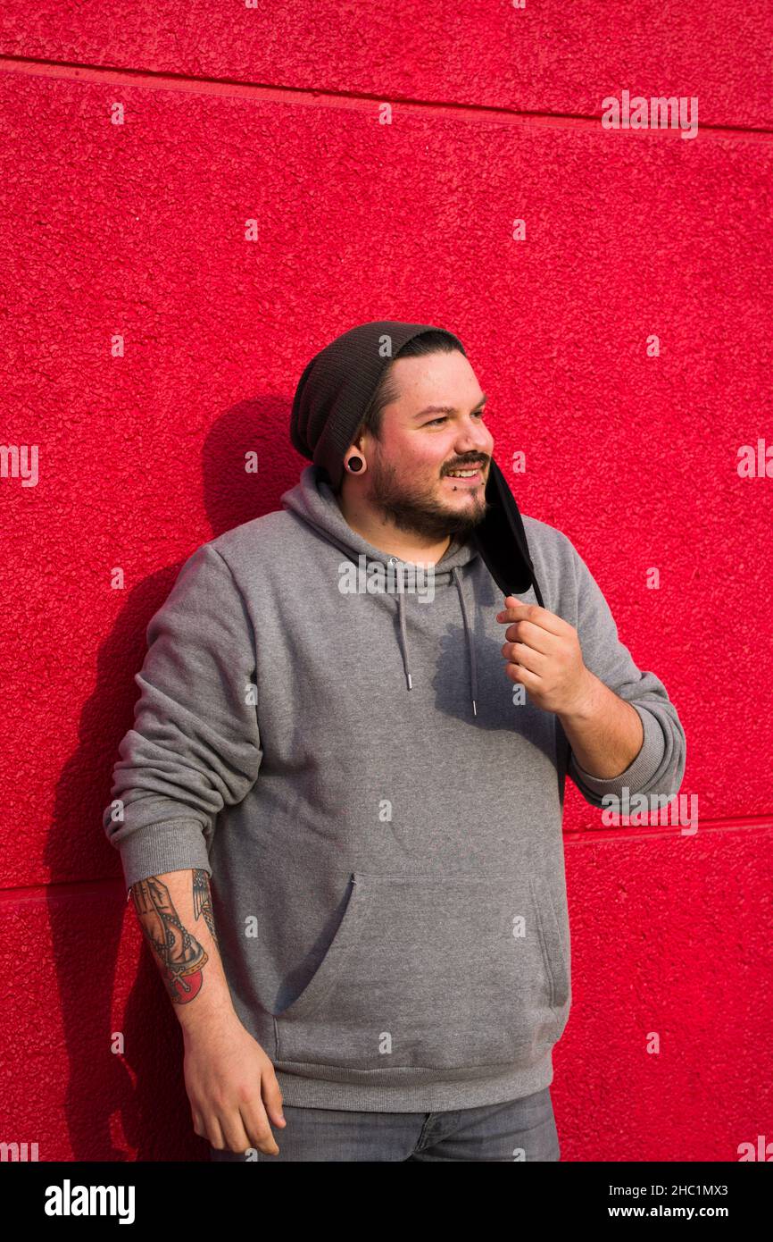 A young smiling caucasian chubby man putting on his face mask against a ...