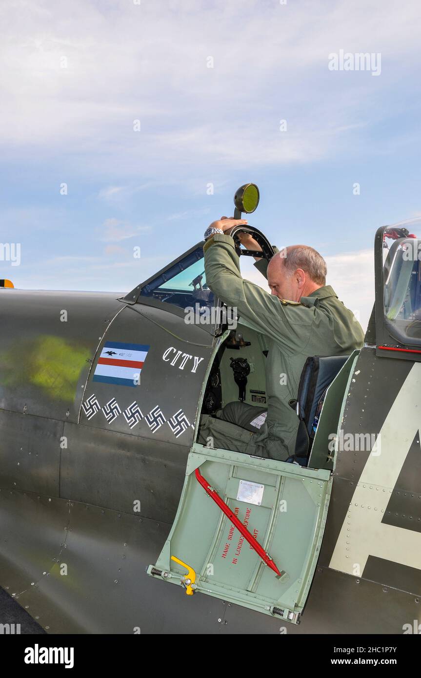 Pilot lowering himself into the cockpit of a restored Second World War ...