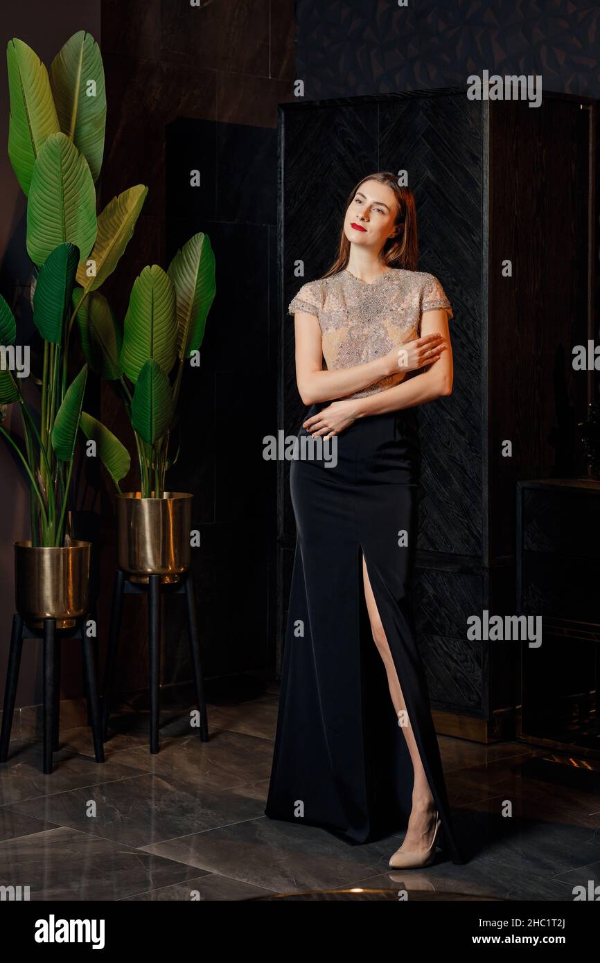 Low key photo of fashion model posing in dress with lace top and deep ...