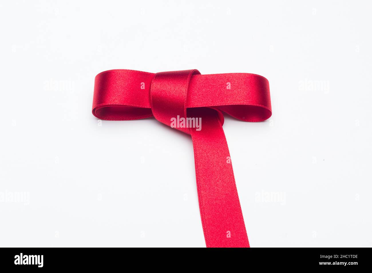 Red ribbon for gift wrapping on a white background Stock Photo - Alamy