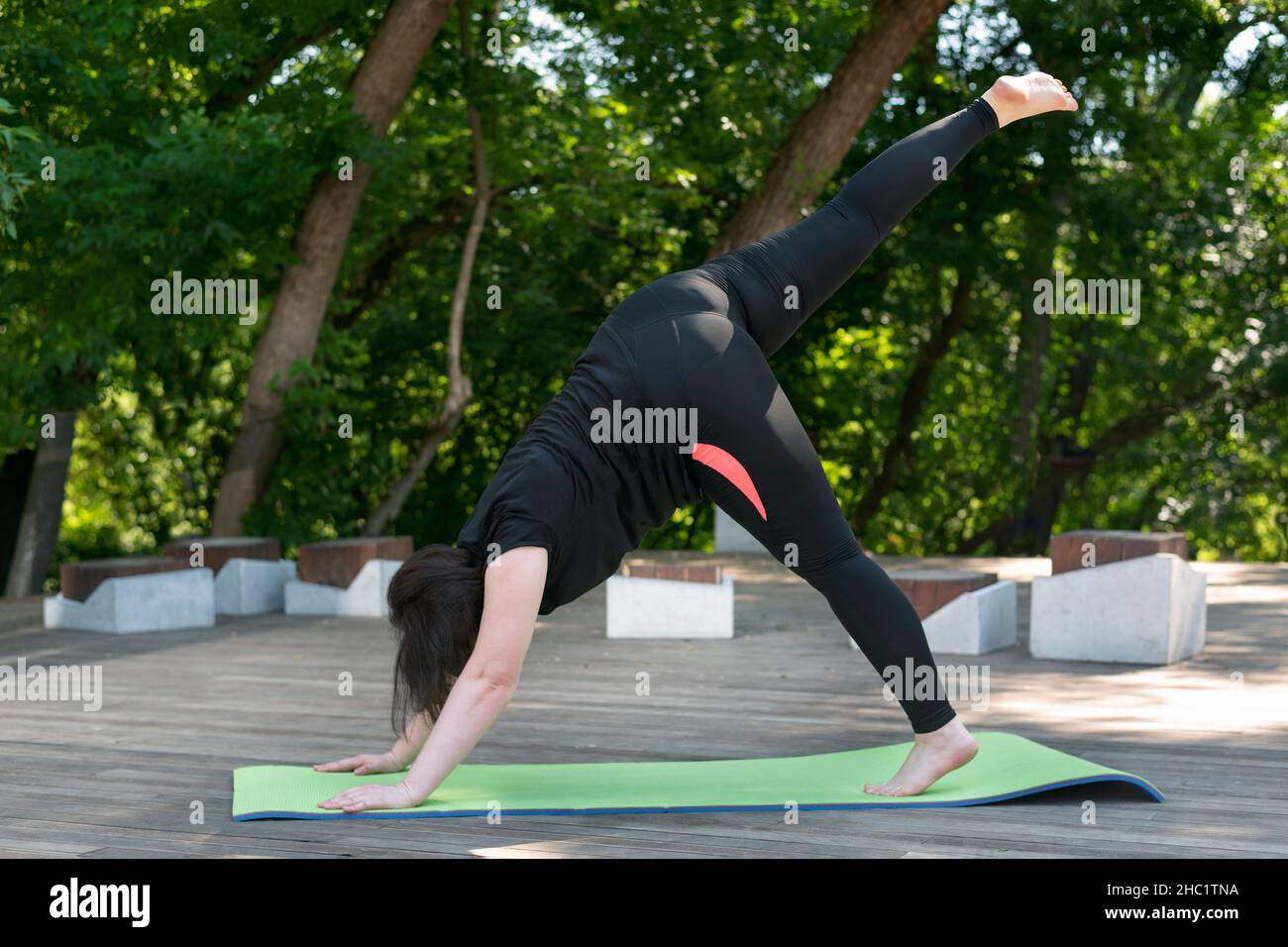 Young beautiful girl performs a modified yoga pose dog muzzle down ...