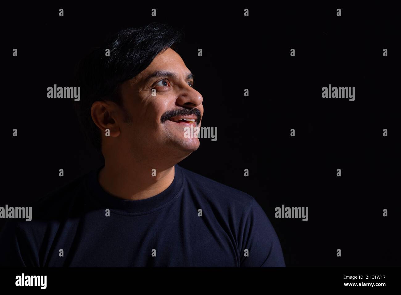 Side view of a common man with black background Stock Photo - Alamy