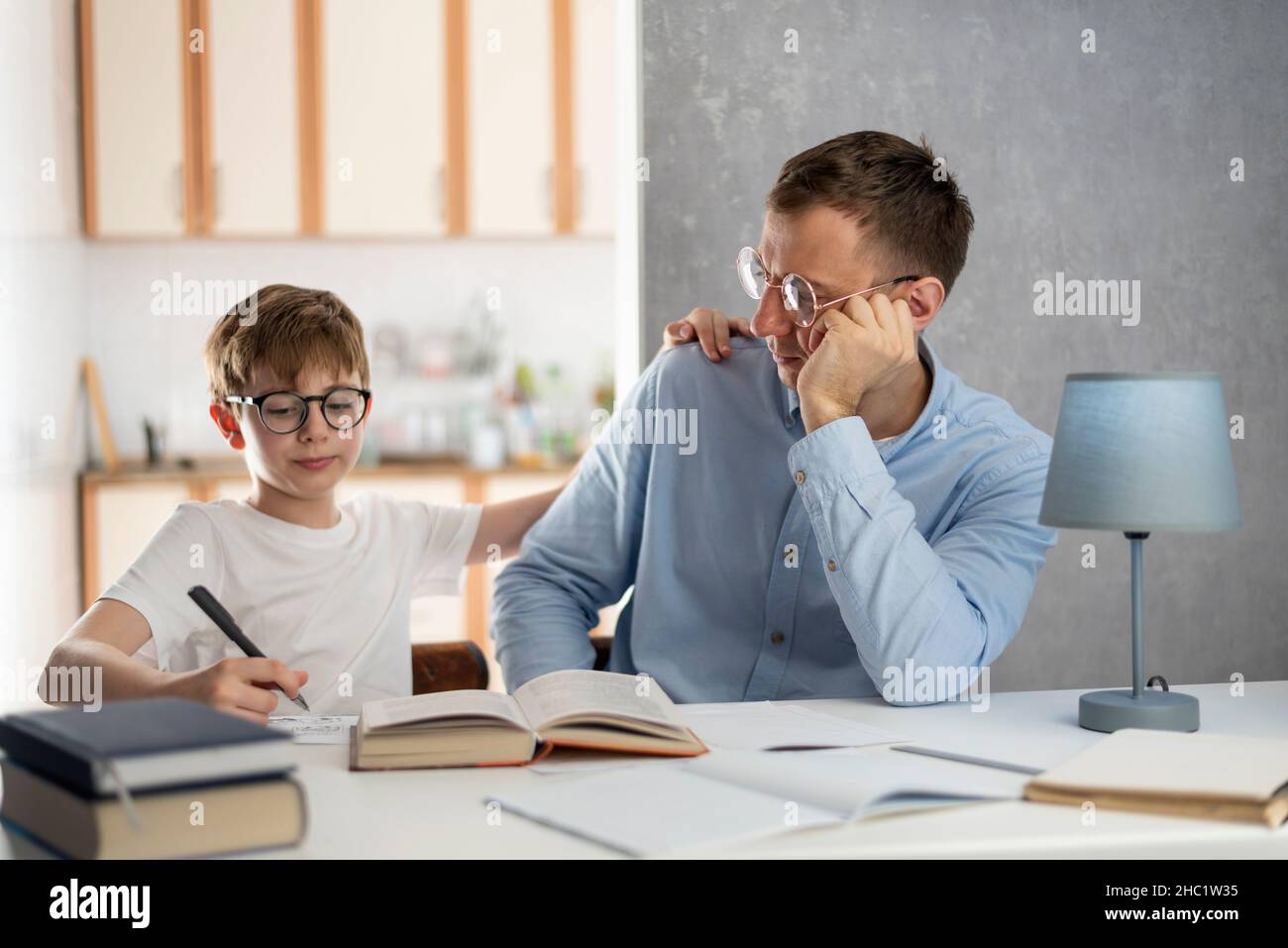 Father and son are doing homework together. Home schooling. Teen boy ...