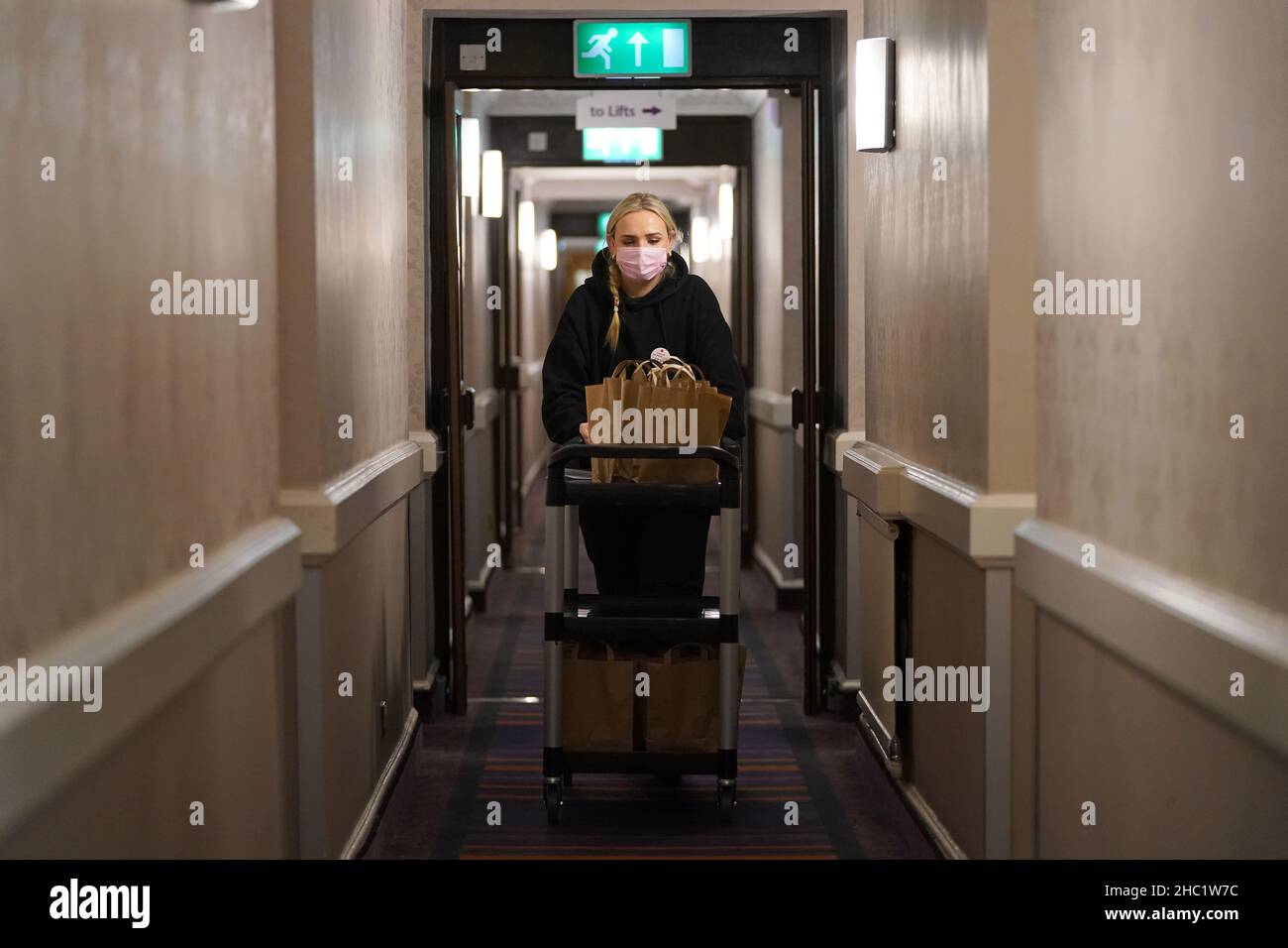 A volunteer delivers breakfast to homeless people in their rooms at a ...