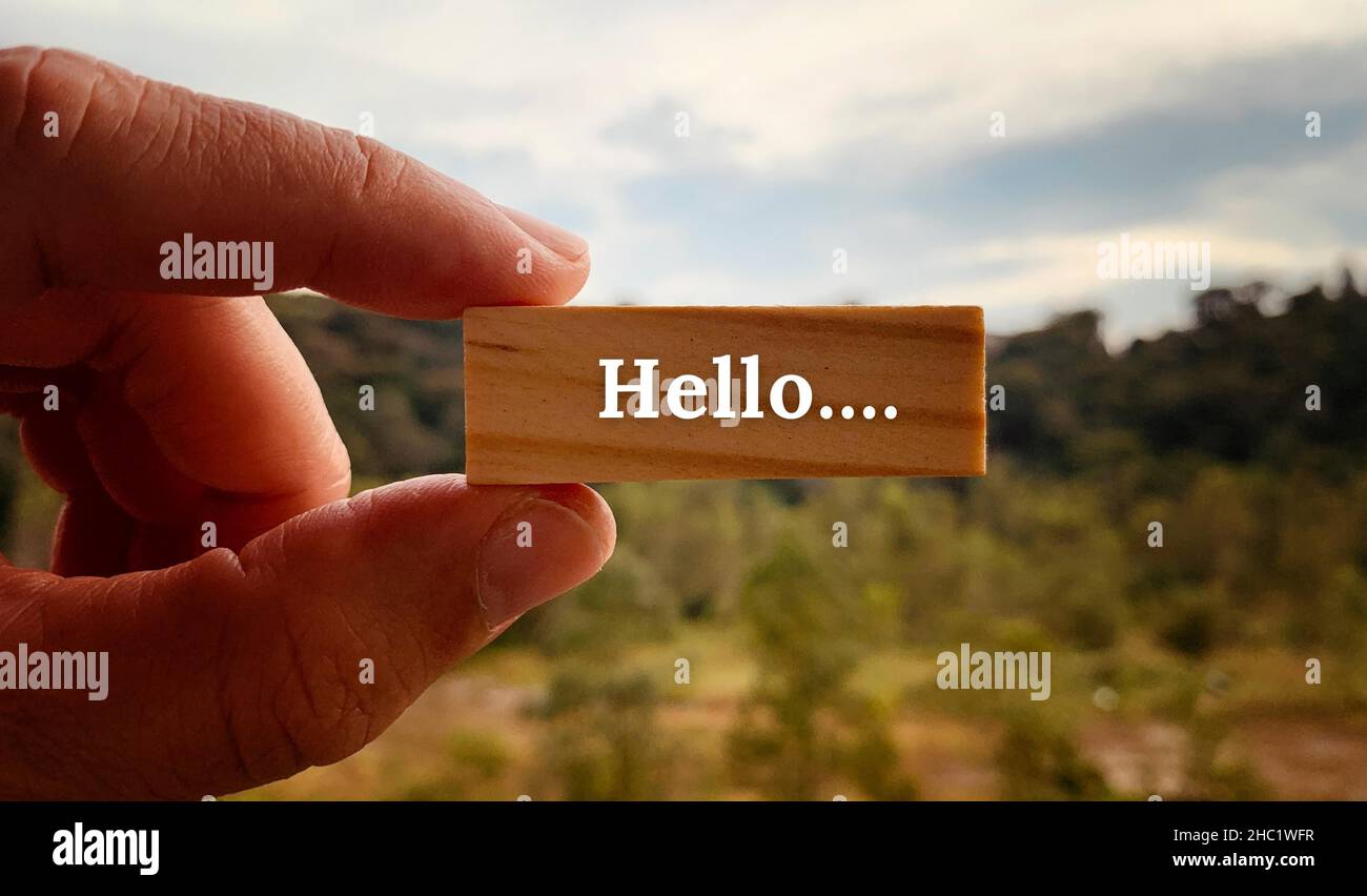 Image with Hello text on a wooden block with a hand holding with and ...