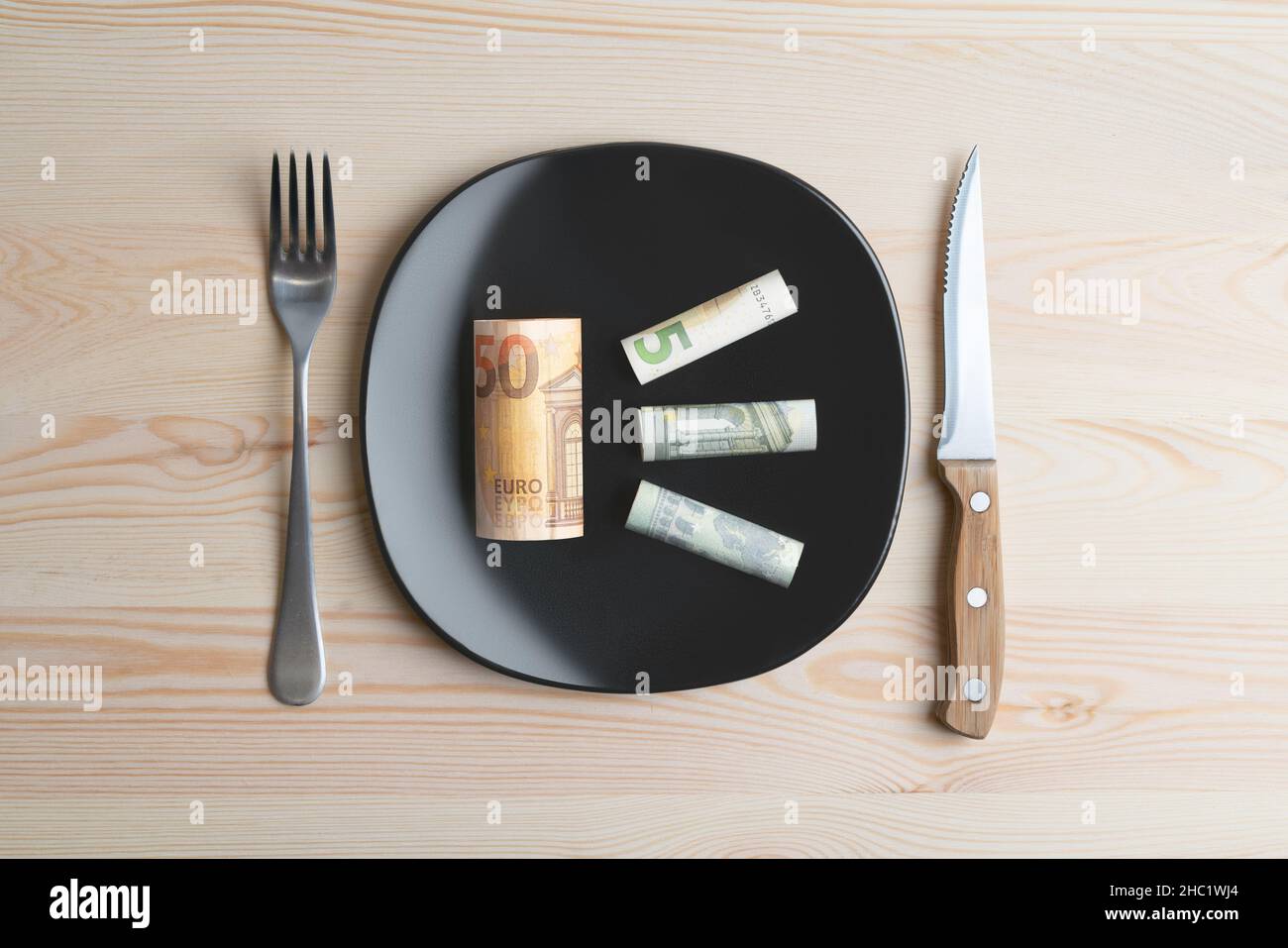 Conceptual studio shot of dinner table with euro bank notes on the ...