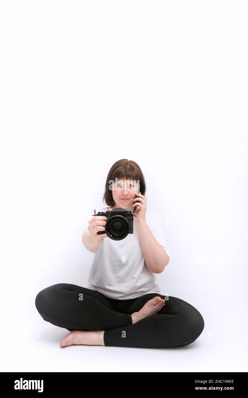Young woman is taking pictures at the same time on the camera and ...