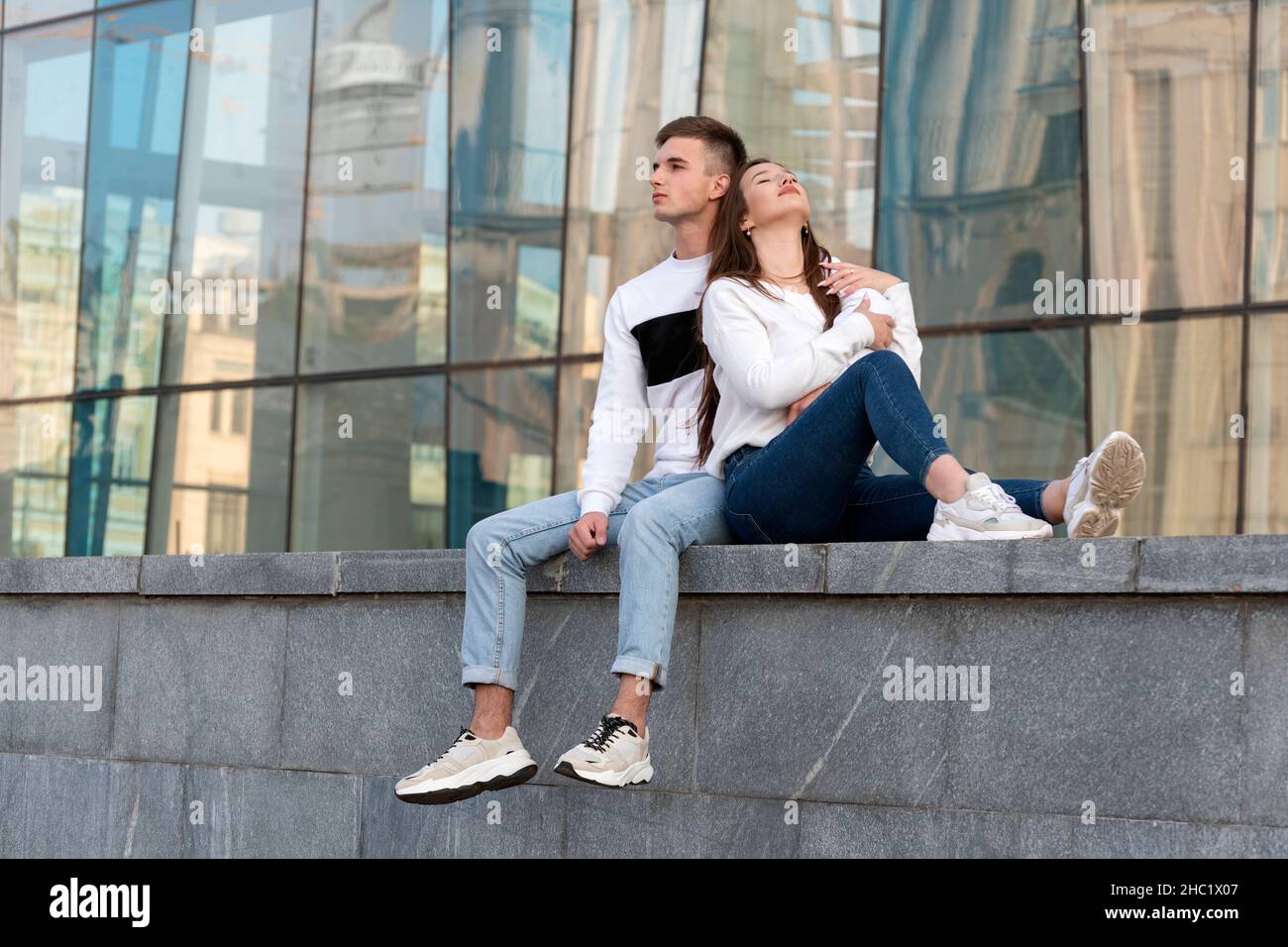 Young loving couple having rest inside in the city. Girl leaned on the ...