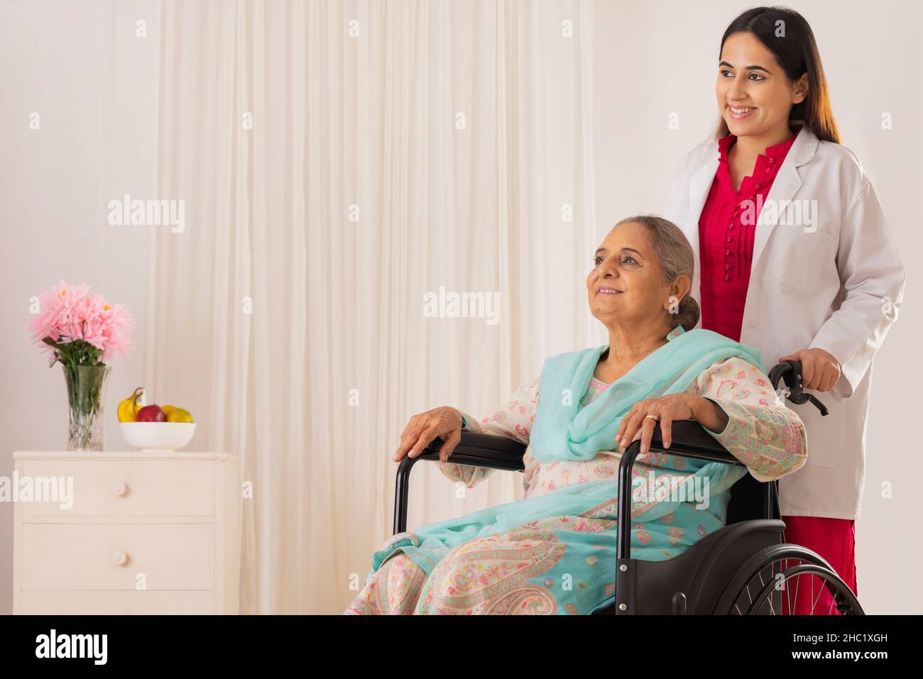 Nurse moving senior woman sitting on wheel chair Stock Photo - Alamy