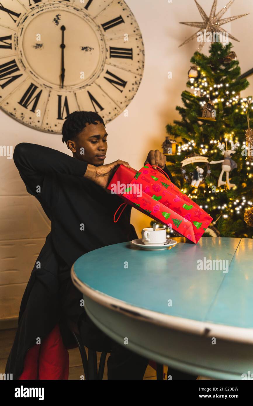 young boy pulling gift from bag Stock Photo - Alamy